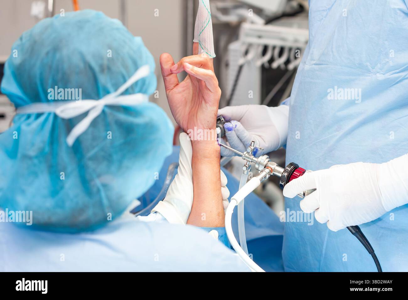 Group of orthopedic surgeons performing a wrist arthroscopy on a male ...