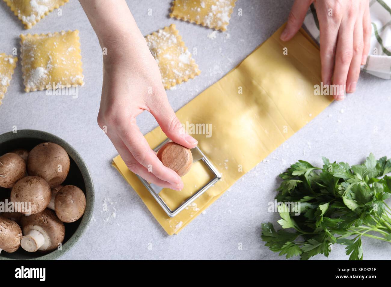 Woman cutting ravioli at light table, top view Stock Photo - Alamy