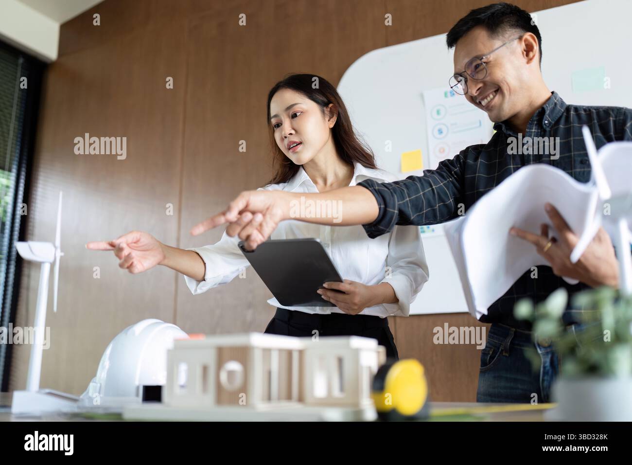 Sustainability and Engineering. Engineers pointing out features of eco ...