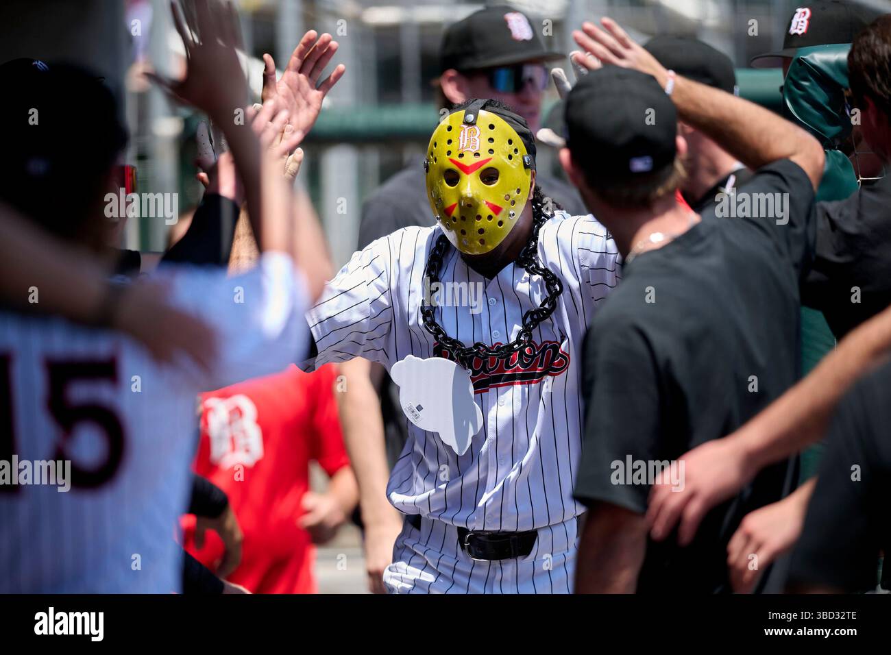 Birmingham Barons DJ Gladney (25) high fives teammates while wearing a ...