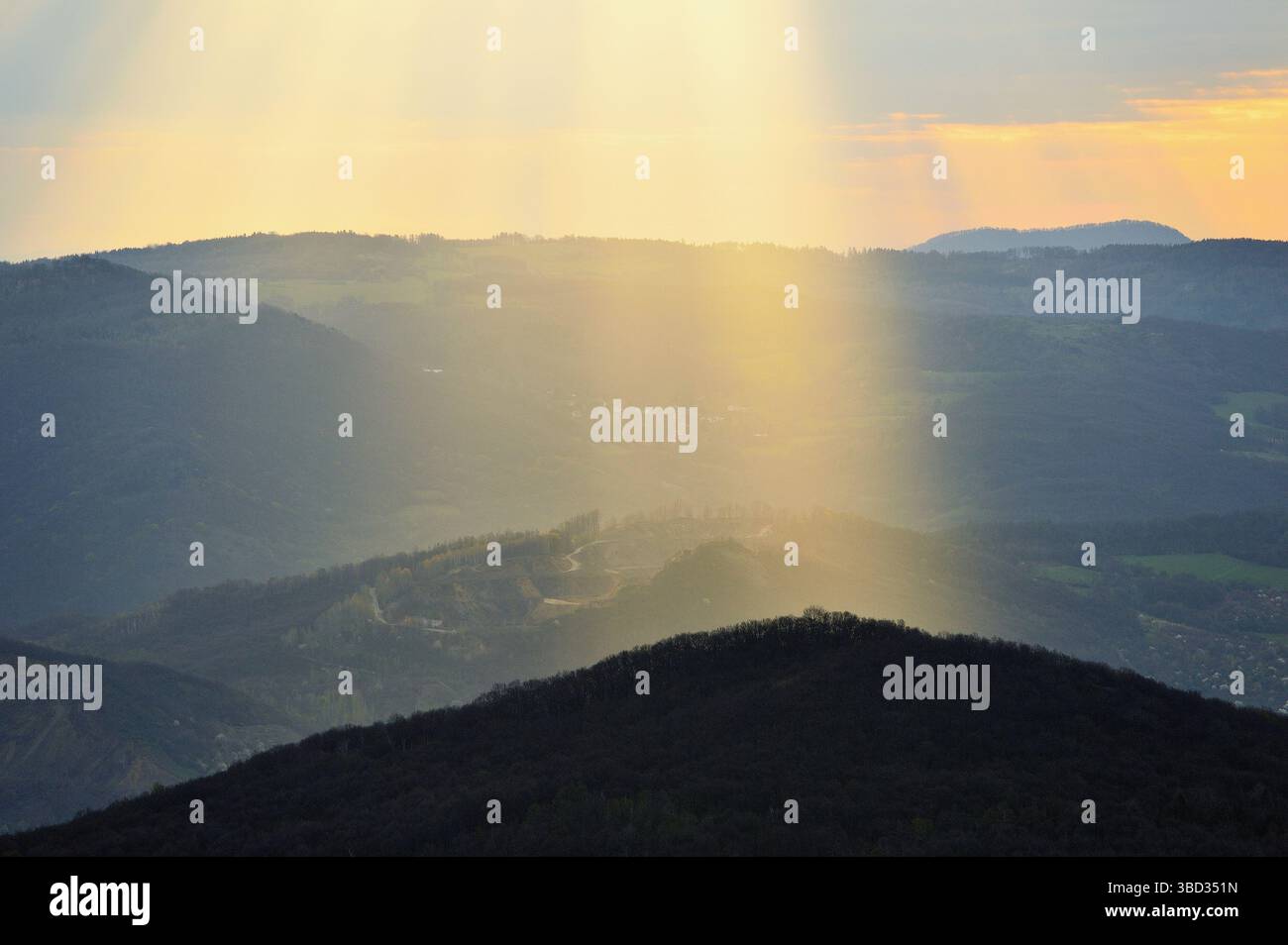 Majestic Light Rays Shining Over Countryside Hills Beneath a Stormy ...