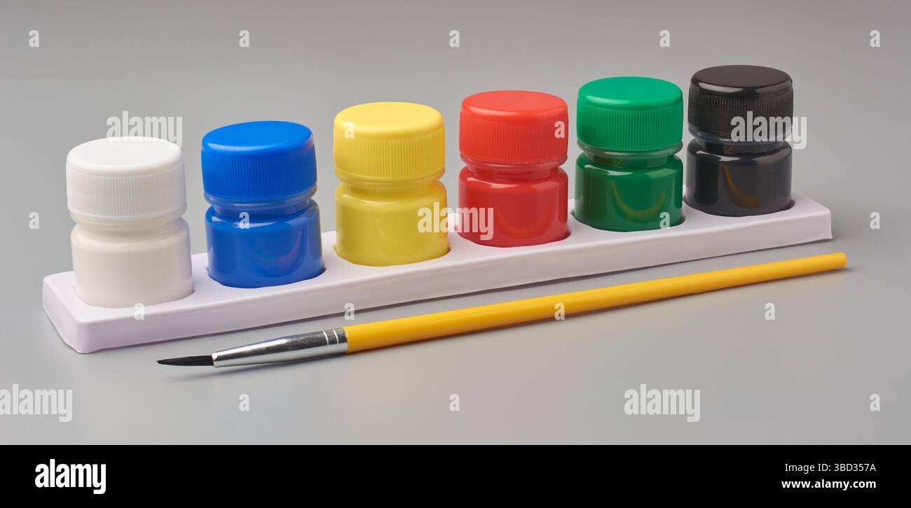 pack of colorful poster color bottles with yellow brush isolated gray ...