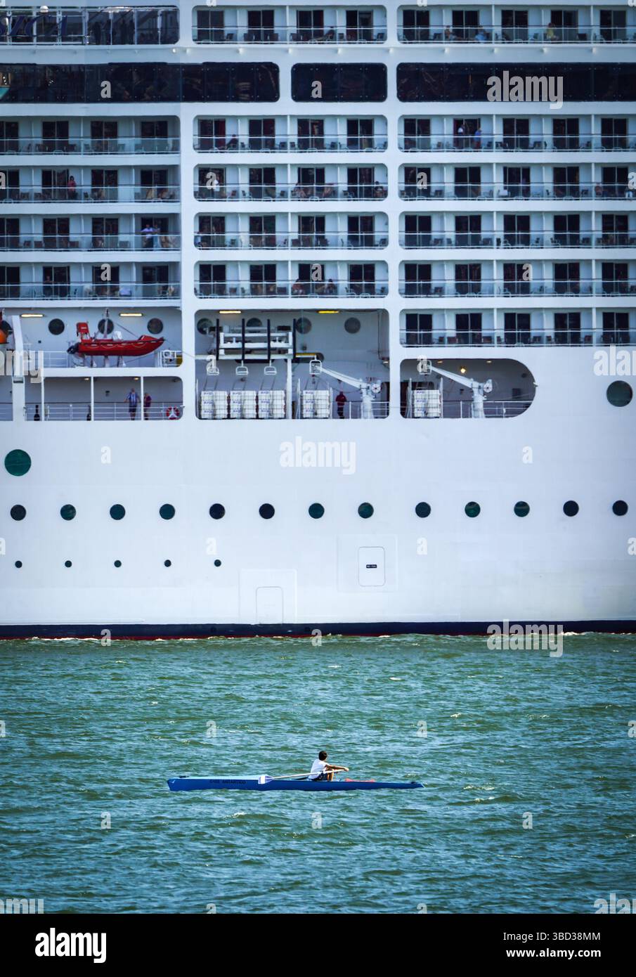 Small rowing boat next to a huge cruise ship on the Targus in Lisbon ...