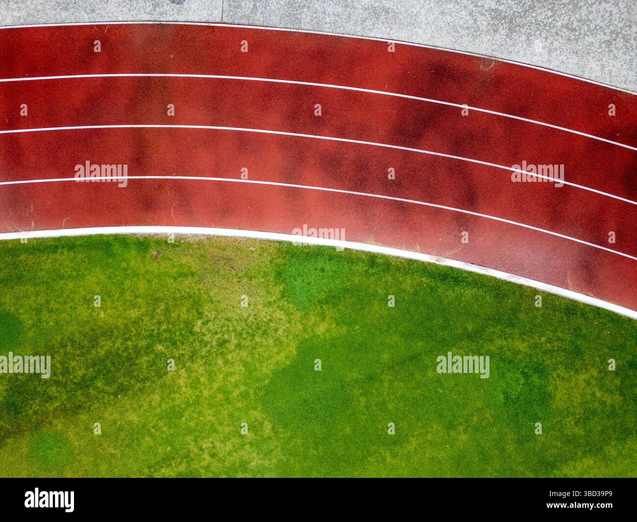 Aerial view of a red running track with marked lanes and curved lines ...