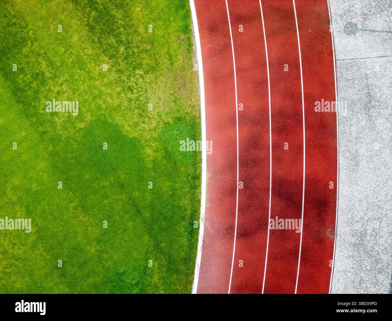 Aerial view of a red running track with marked lanes and curved lines ...