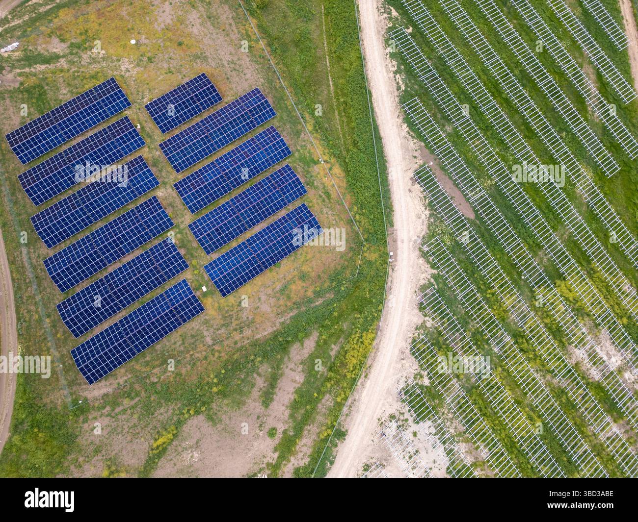Aerial view of solar panels and mounting structures in a rural area ...