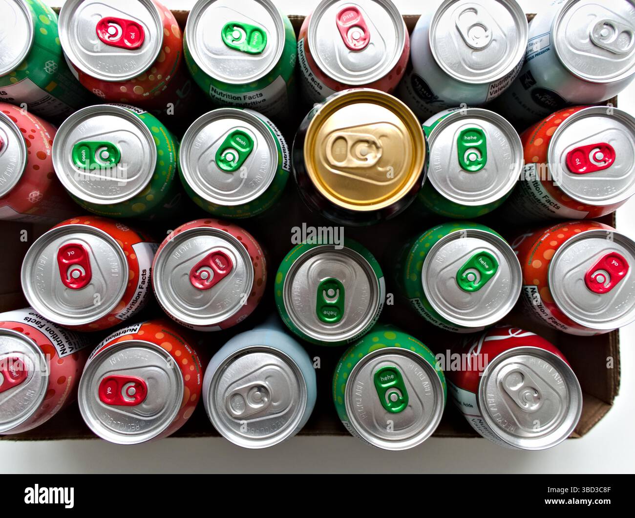 A box of soda cans with a single can that is gold. The other cans are ...