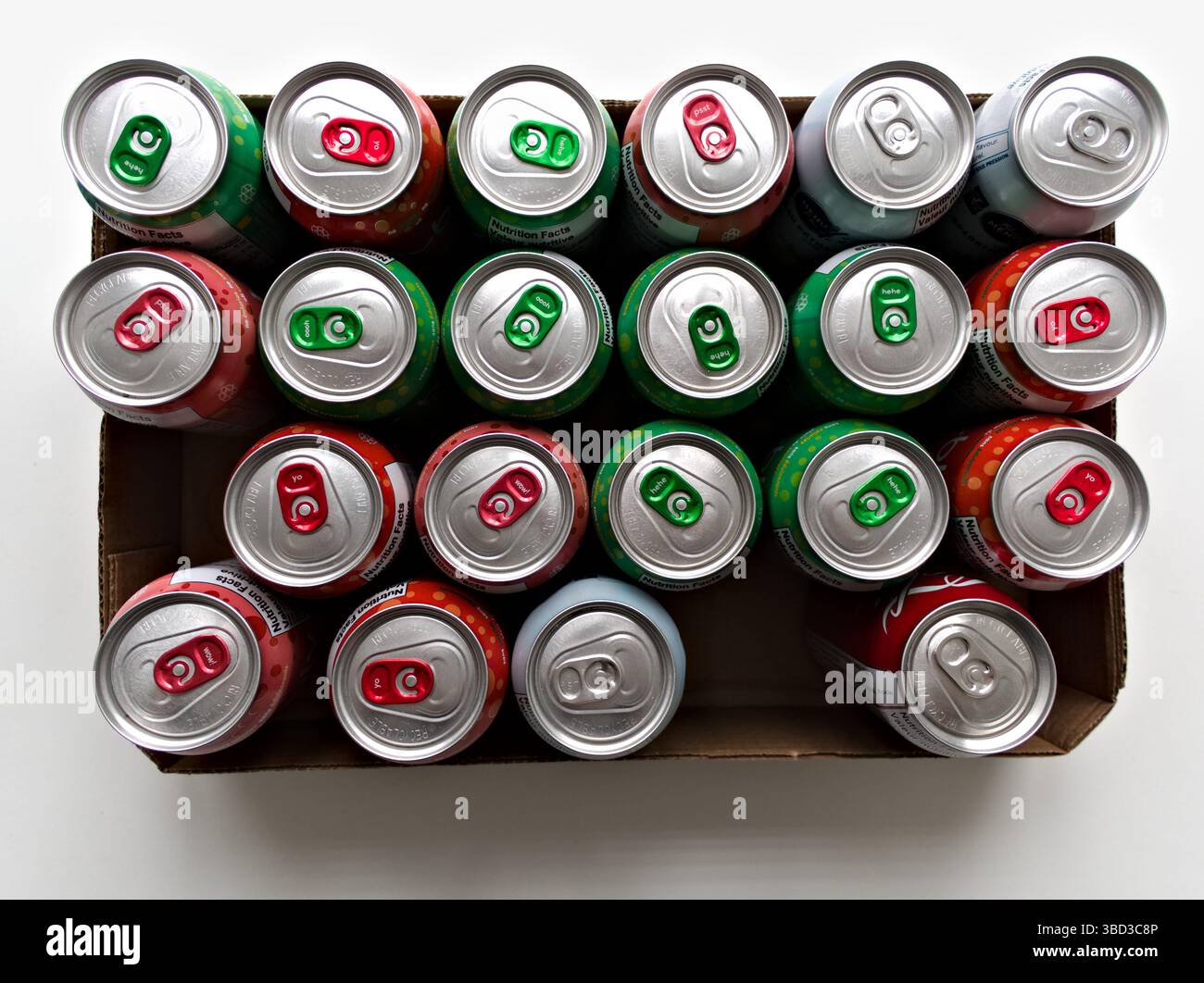 A box of soda cans with a green can in the middle. The cans are lined ...