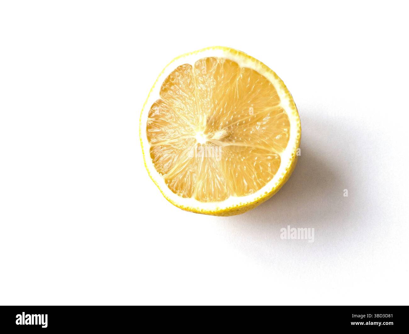 A lemon is sliced in half and the inside is shown. The lemon is yellow ...