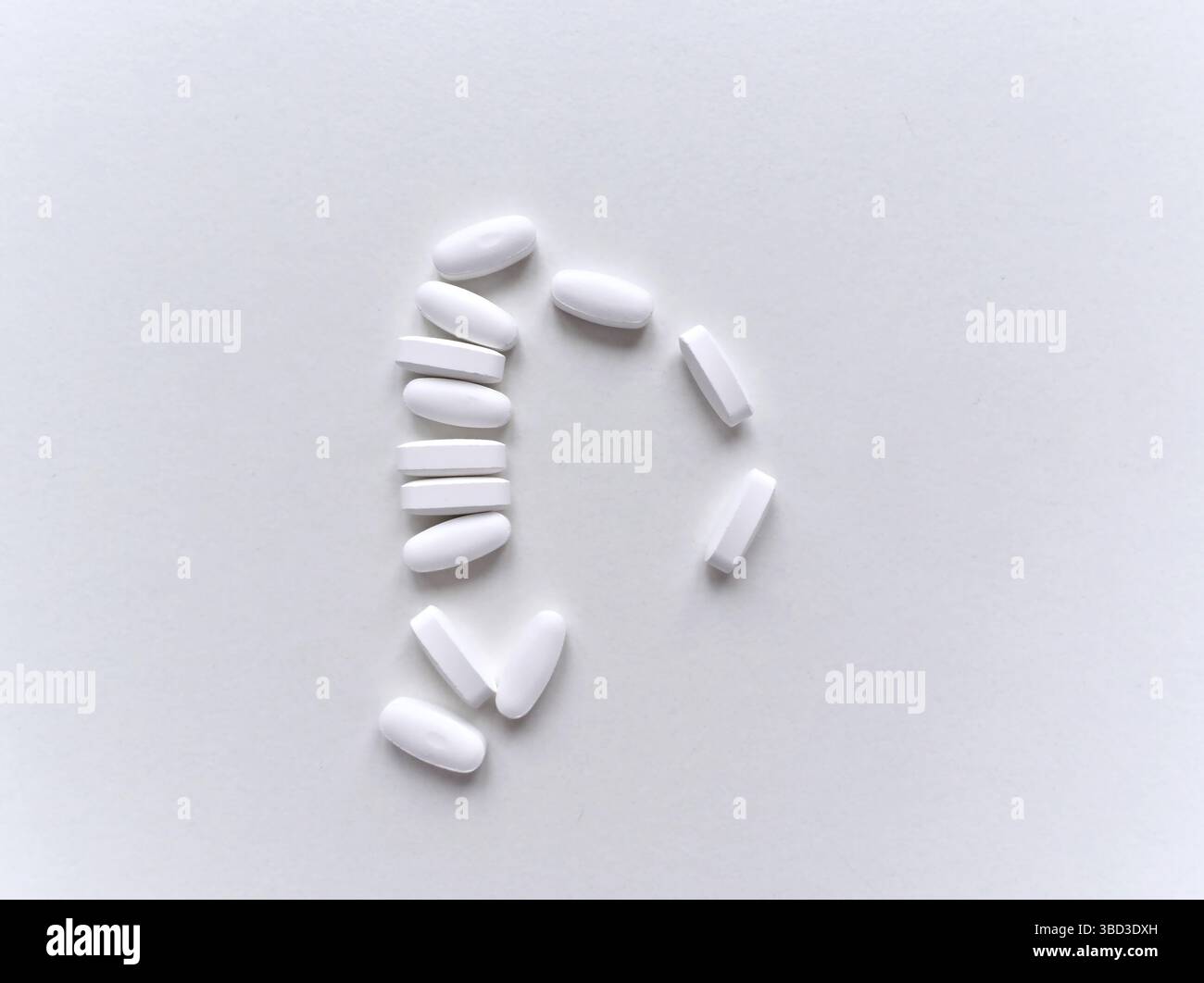 A white pill bottle with a white pill inside. The pill bottle is in the ...