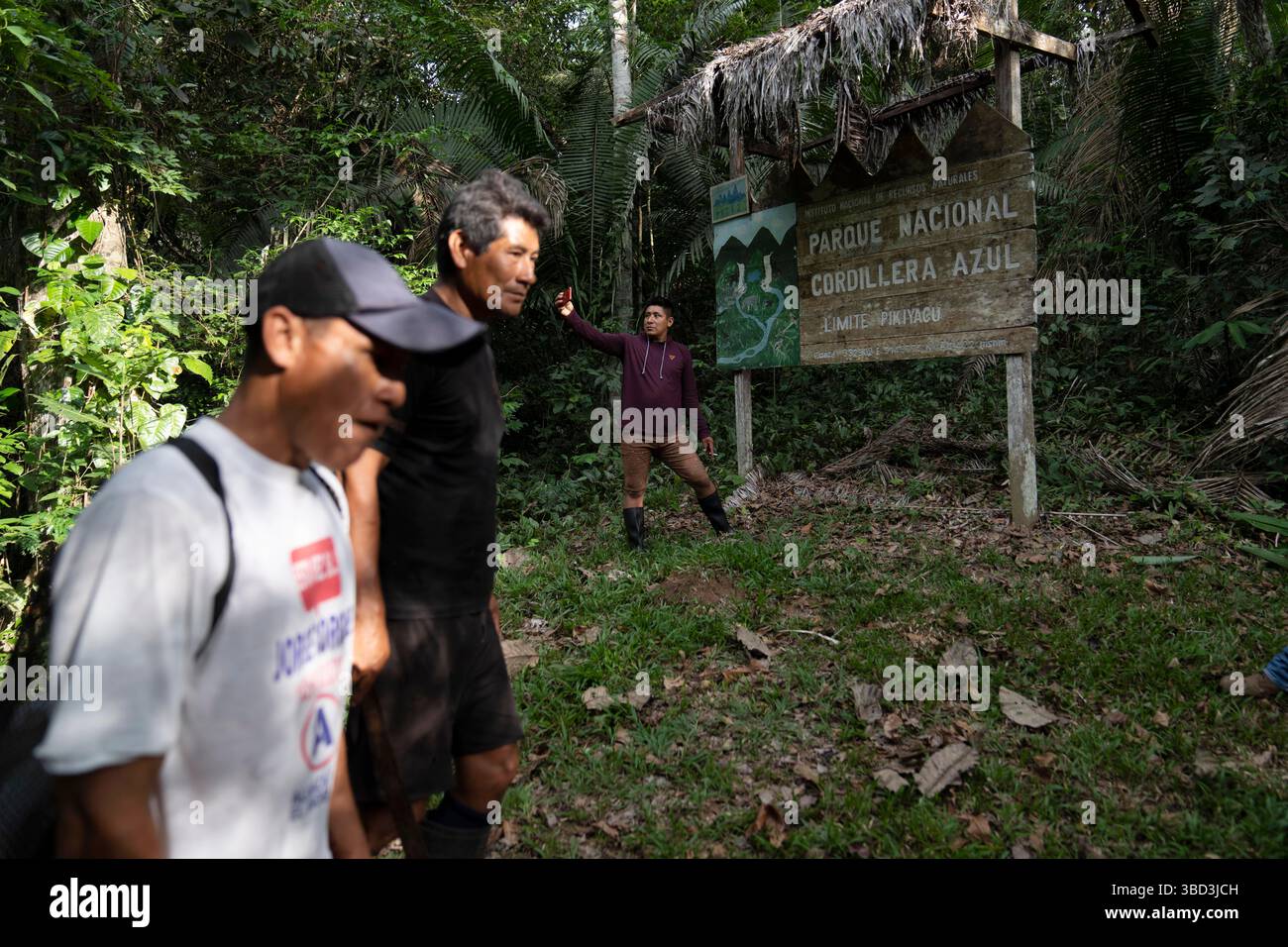FILE - A group of men pass in front of a sign announcing the limit of ...