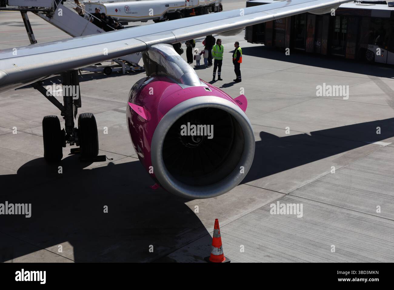 A striking close-up of a pink aircraft engine showcases its intricate ...