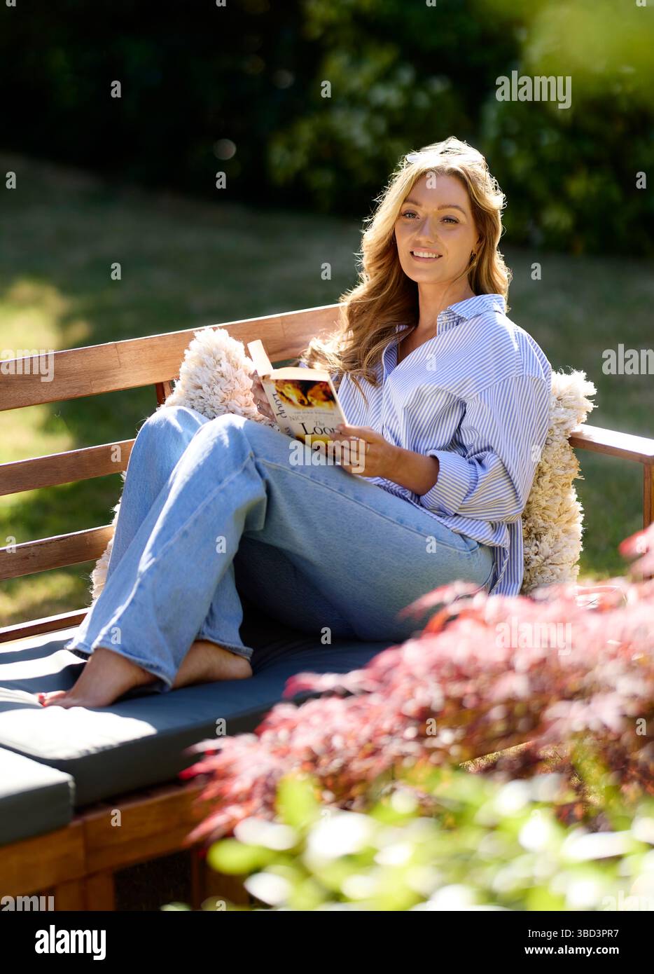 Attractive woman reading gardening book outdoors Stock Photo - Alamy