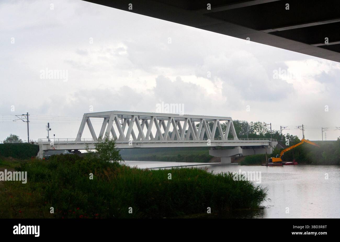 Steel railway bridge across a calm river with clear reflection ...