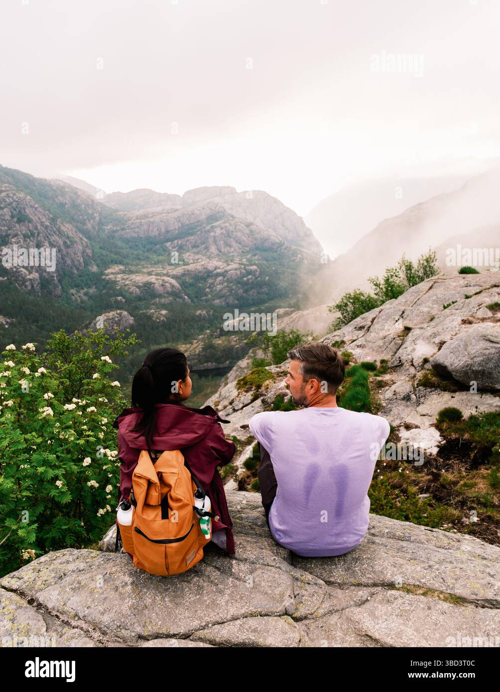 Couple sit on rocky ledge hi-res stock photography and images - Alamy