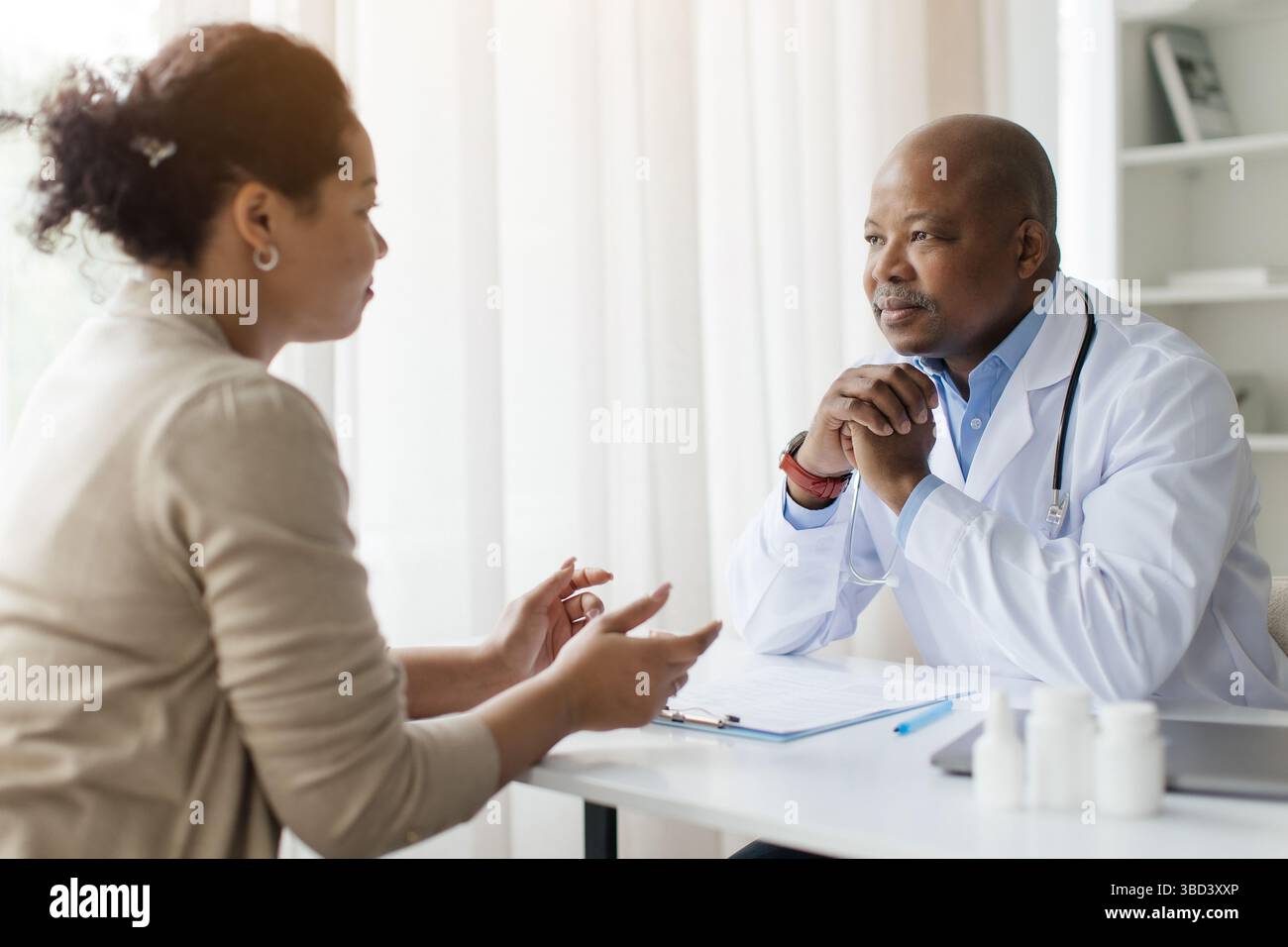 Friendly conversation between African American doctor and woman patient ...