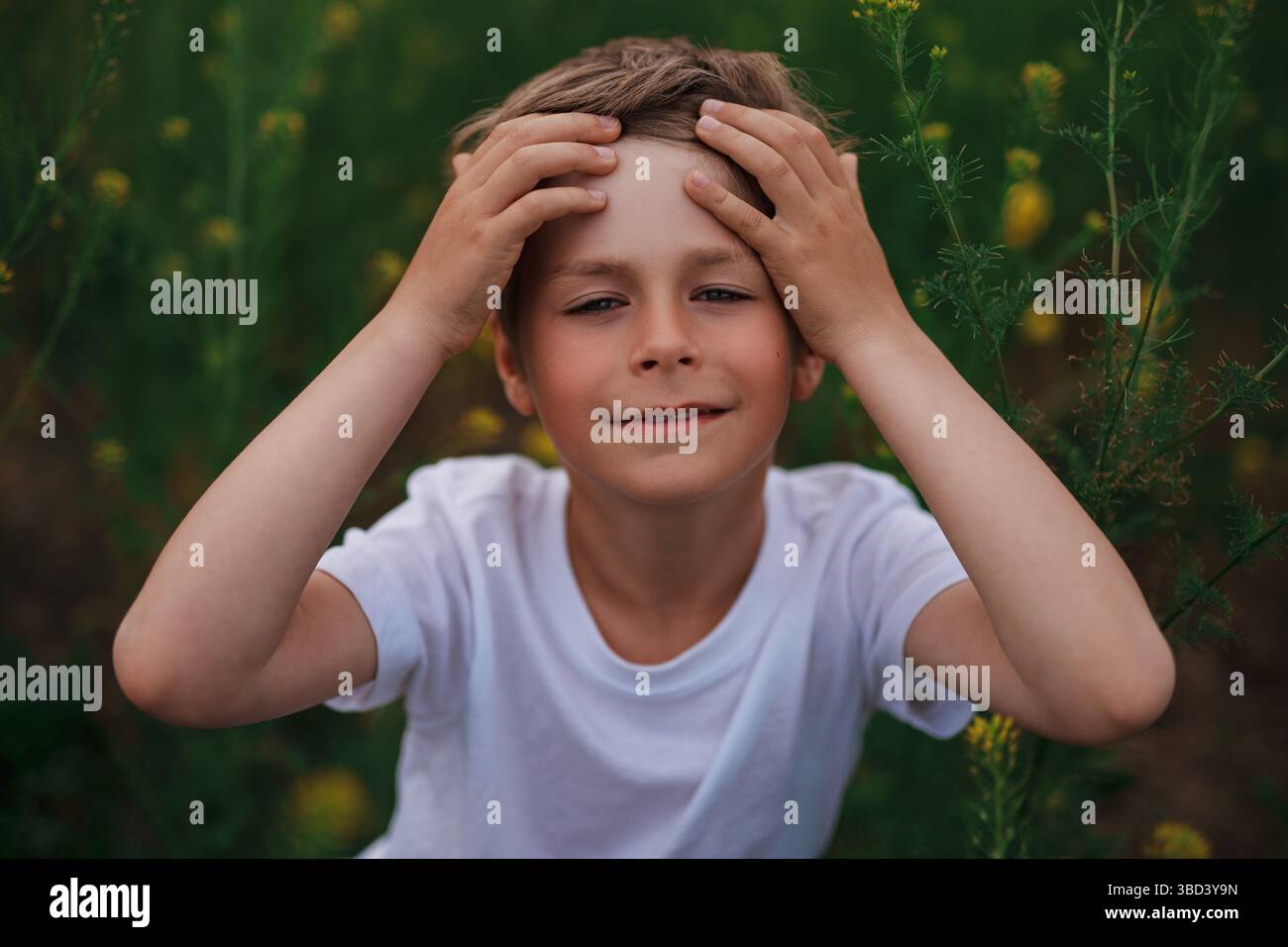 Portrait of cute boy in a flower meadow in summer Stock Photo - Alamy