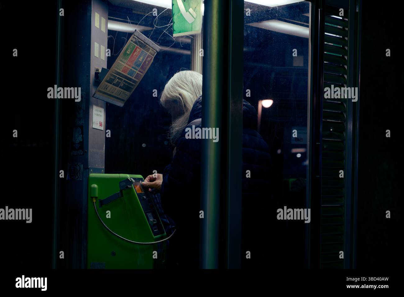 A white-haired figure in a dark puffy jacket dials inside a glowing ...