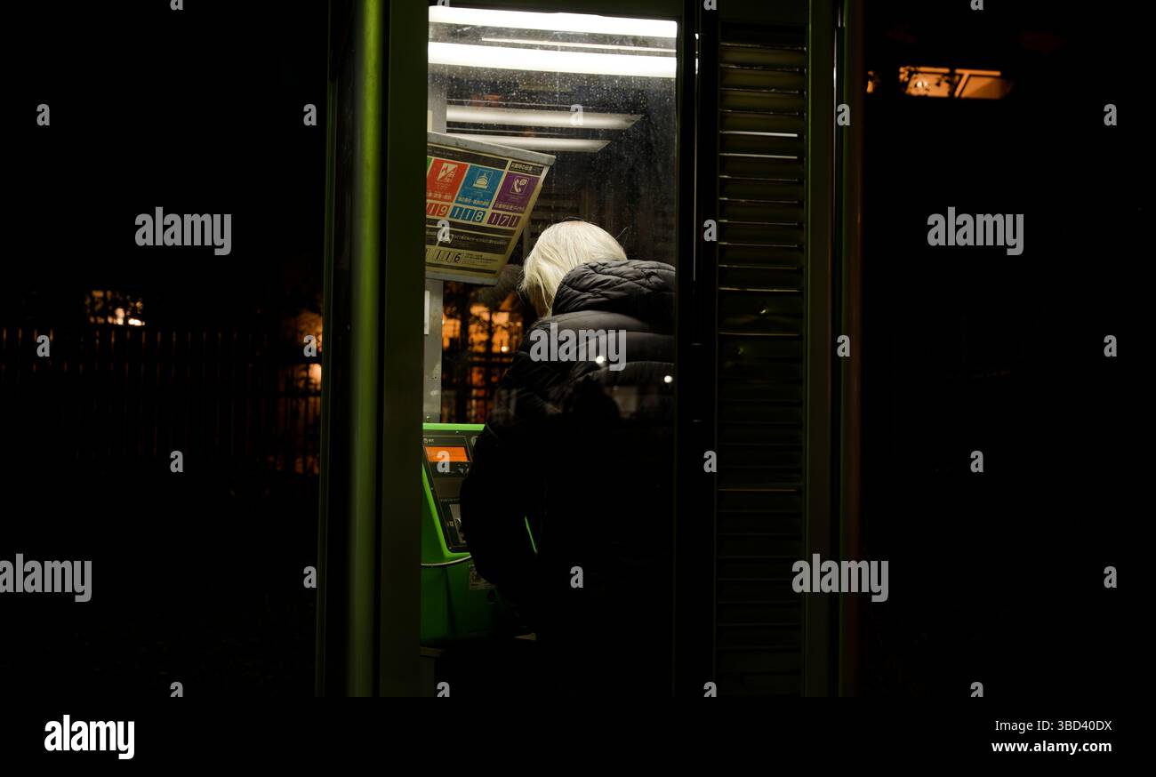 A silver-haired figure dials quietly in a glowing green phone booth ...