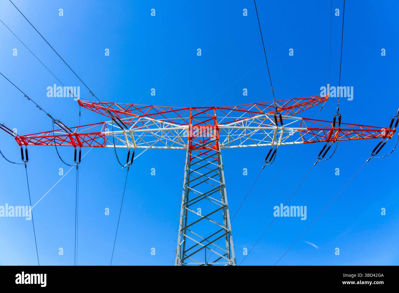 High-voltage pylon, overhead power lines, with red and white markings ...
