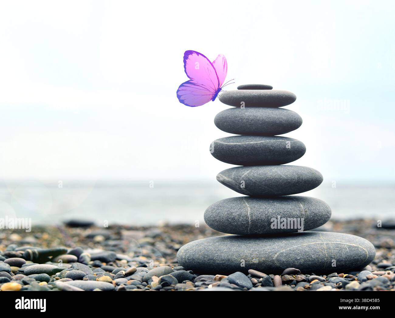 Stone tower. Natural pebble stone and butterfly on the beach. Balancing ...
