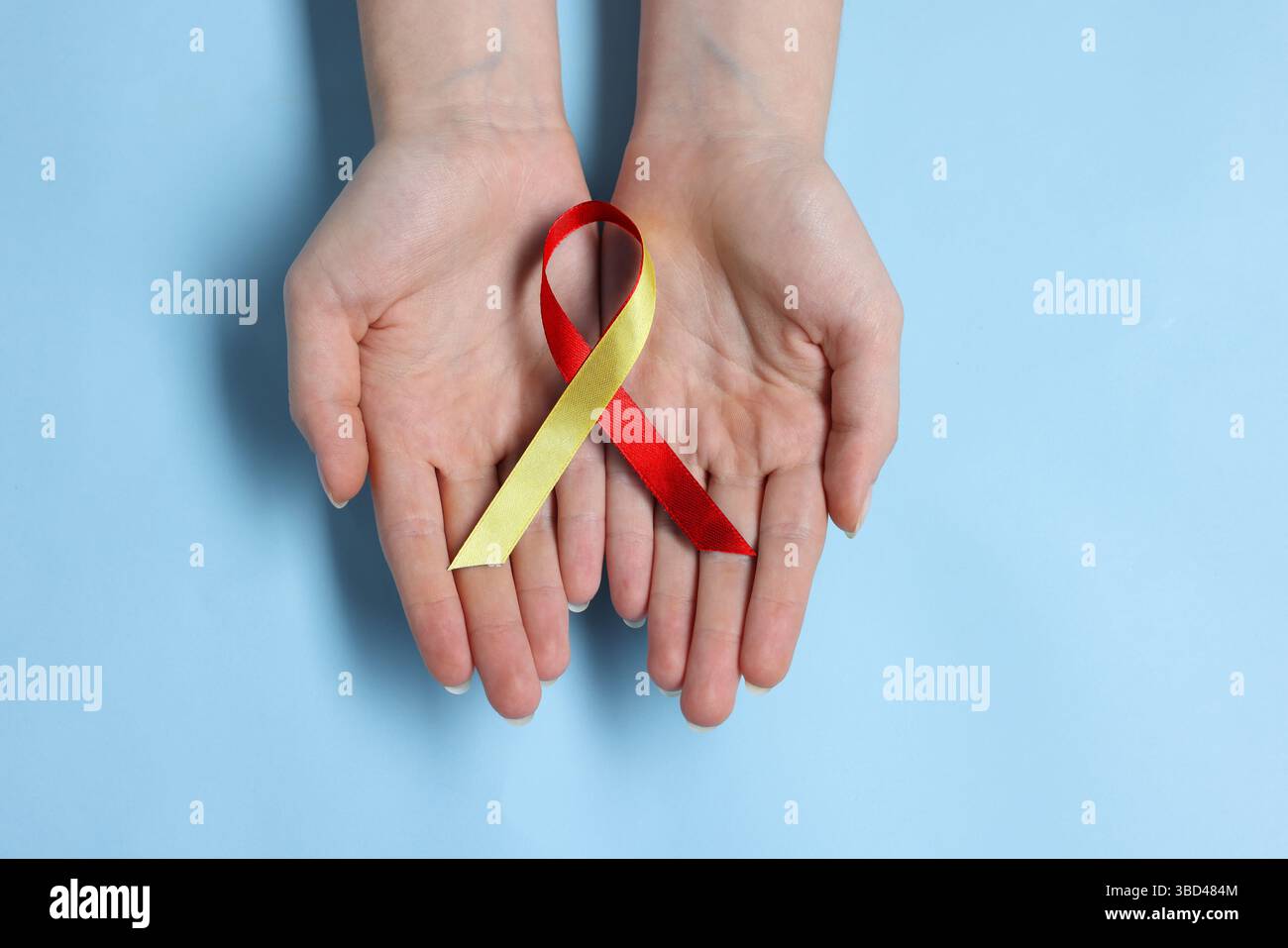World Hepatitis Day. Woman with yellow-red awareness ribbon on light ...