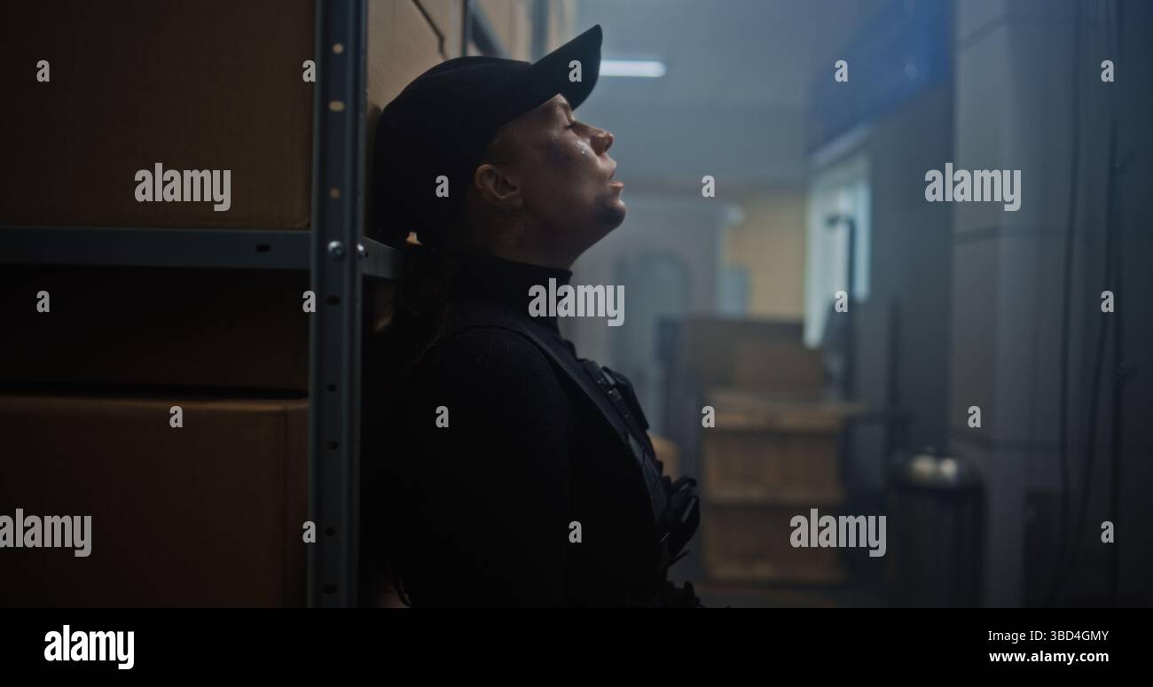 Female Secret Agent in Black Tactical Gear and Cap Hiding in Warehouse ...