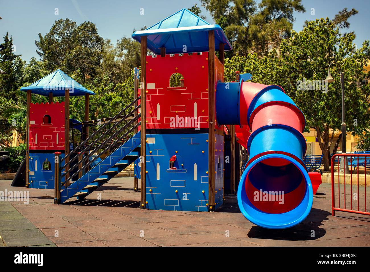 Bright and colorful castle-themed playground with a spiral tube slide ...