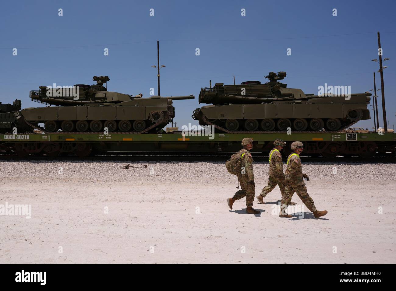 U.S. Army personnel load and secure military tanks for transport to ...