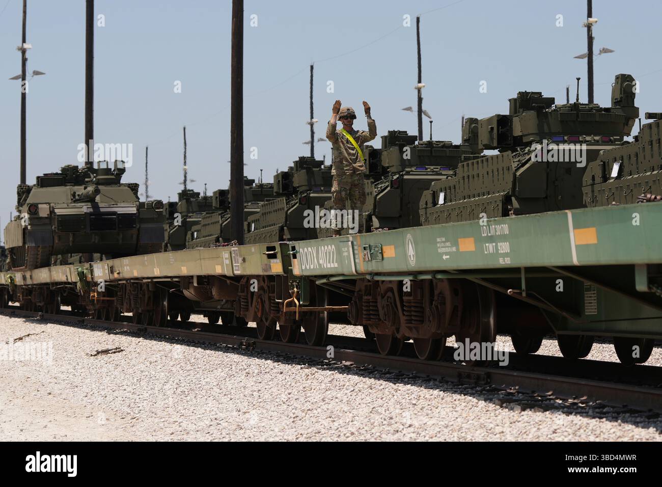 U.S. Army personnel load and secure military tanks for transport to ...