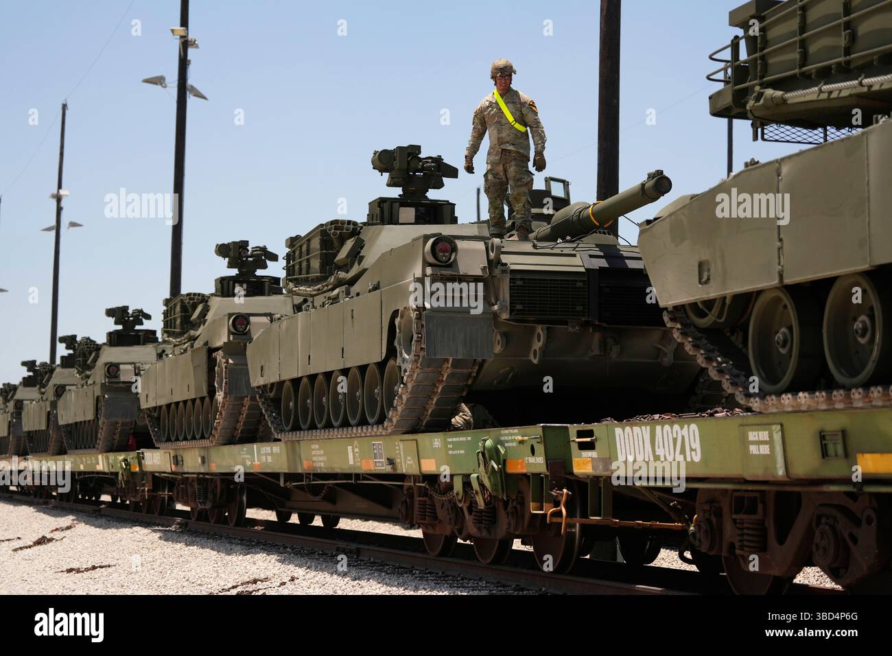 U.S. Army personnel load and secure military tanks for transport to ...