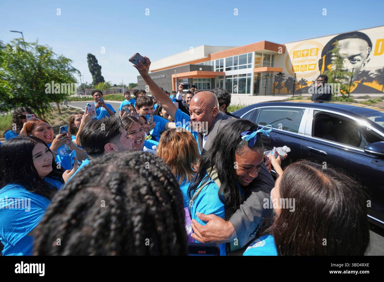 Dr. Andre Dre, middle, is hugged by students as he arrives to a ribbon ...