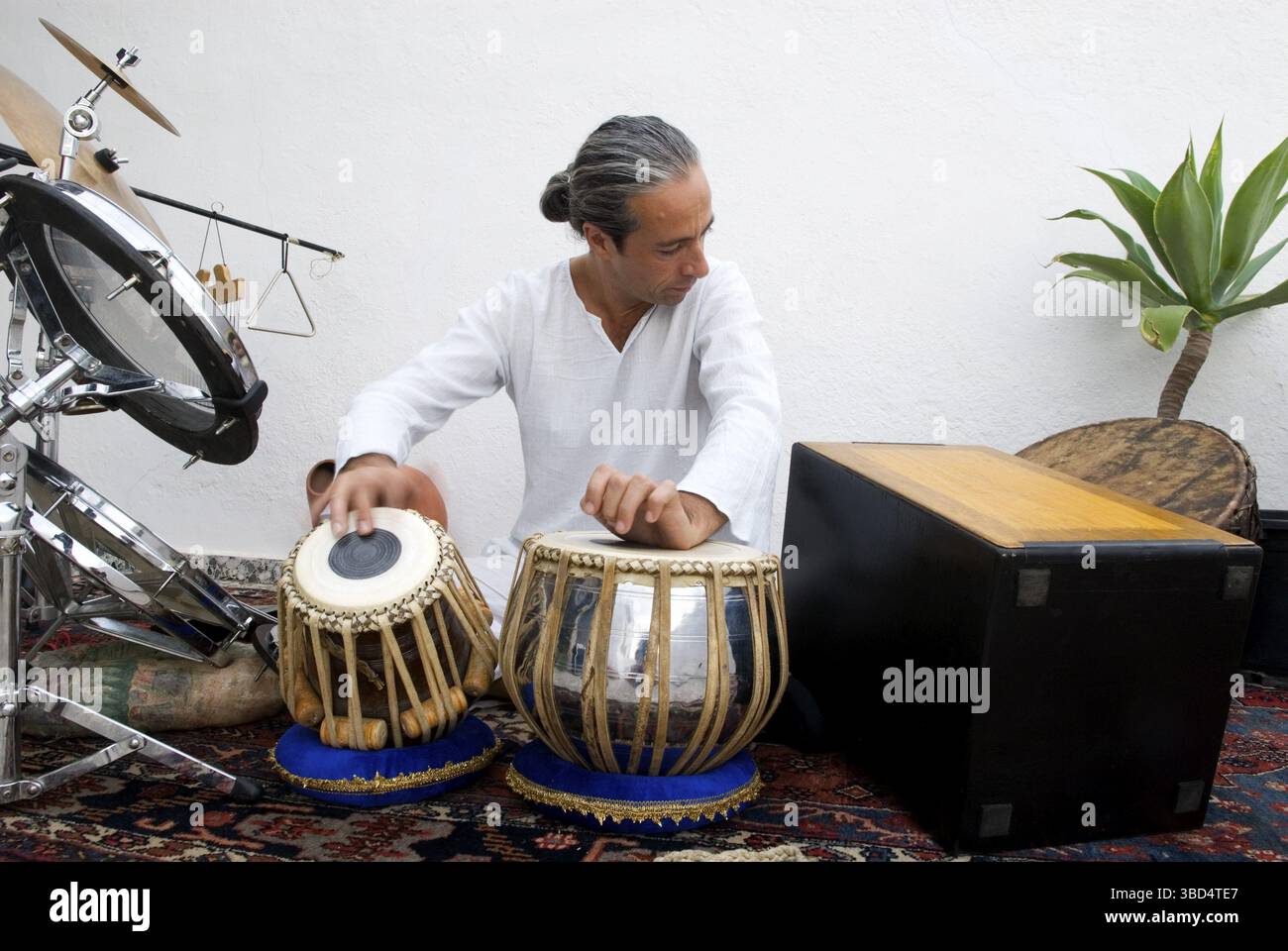 Musician in his early 40's, playing tablas, a north Indian percussion ...