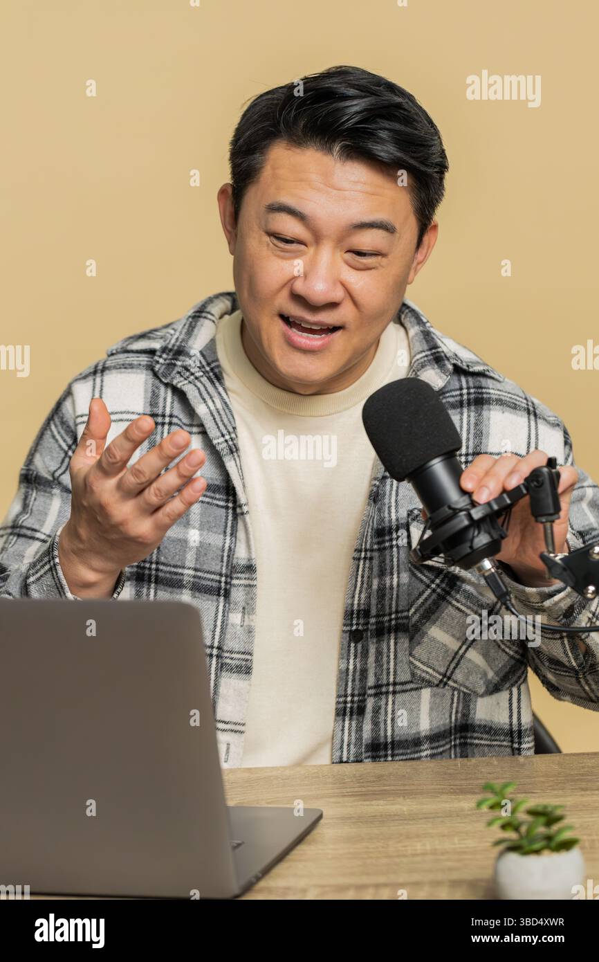 Happy excited blogger Asian man at table recording podcast giving ...