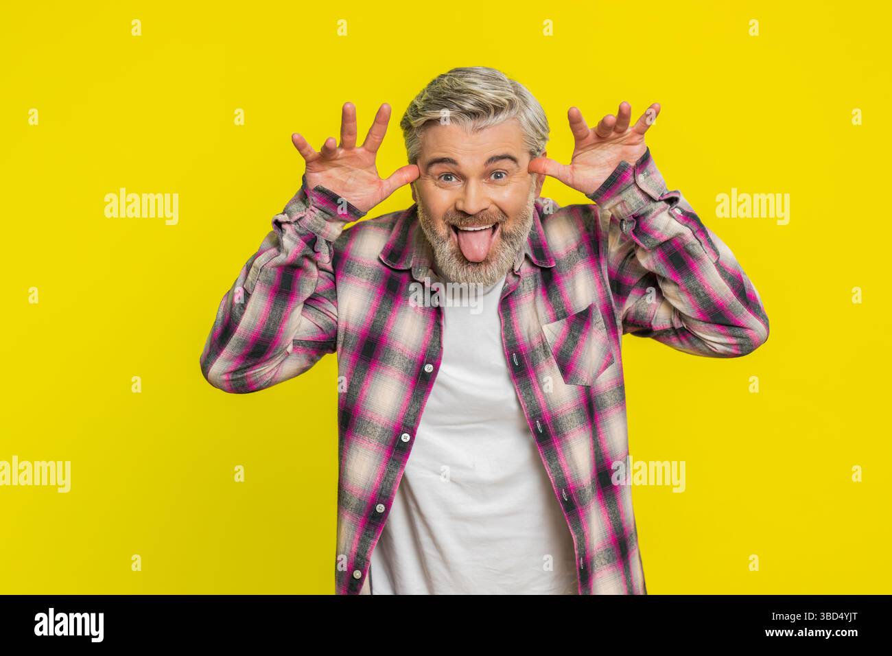 Caucasian, middle-aged mature man on yellow background showing carefree ...