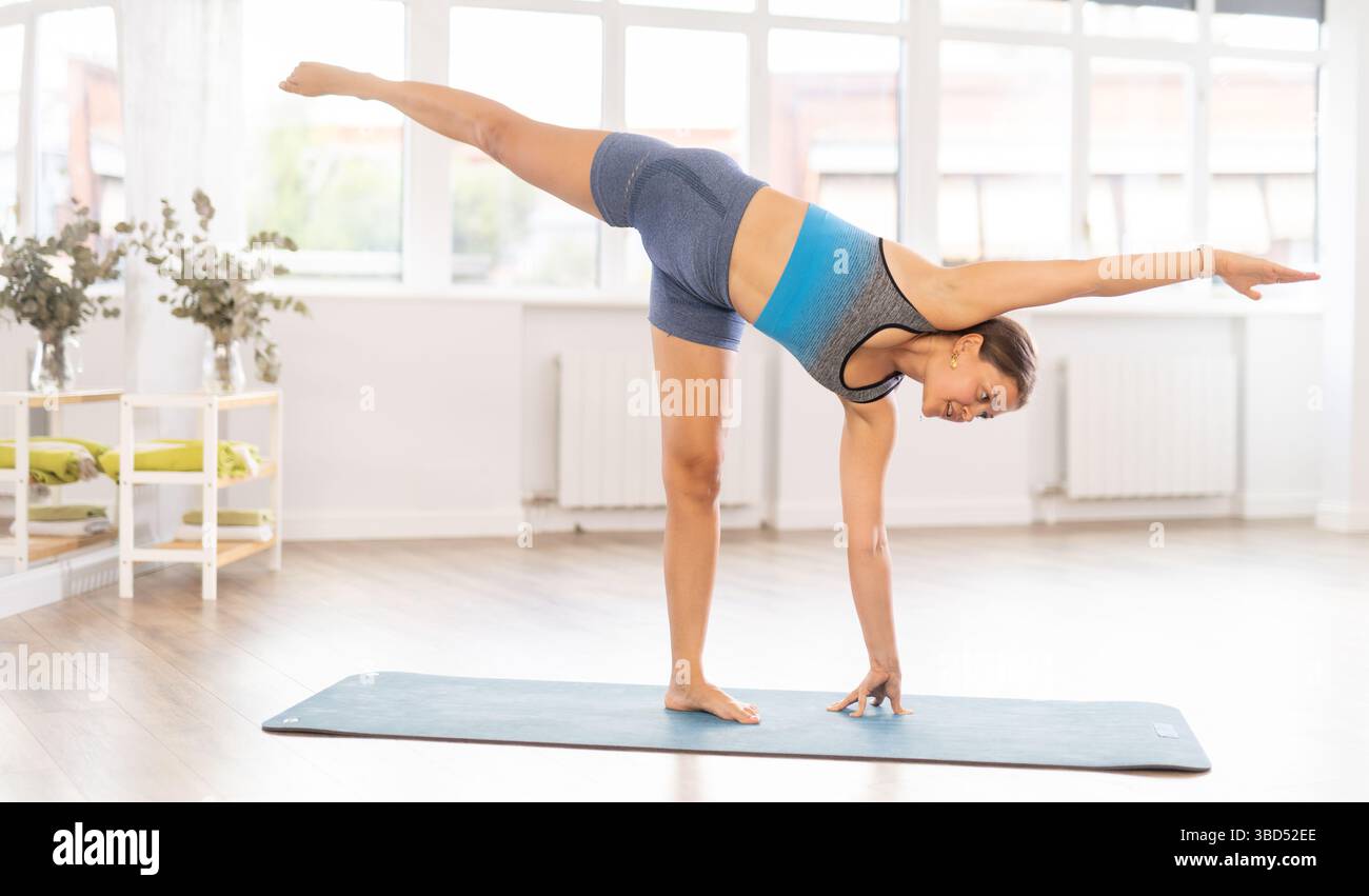 Sporty girl performing powerful dynamic yoga asanas in studio Stock ...