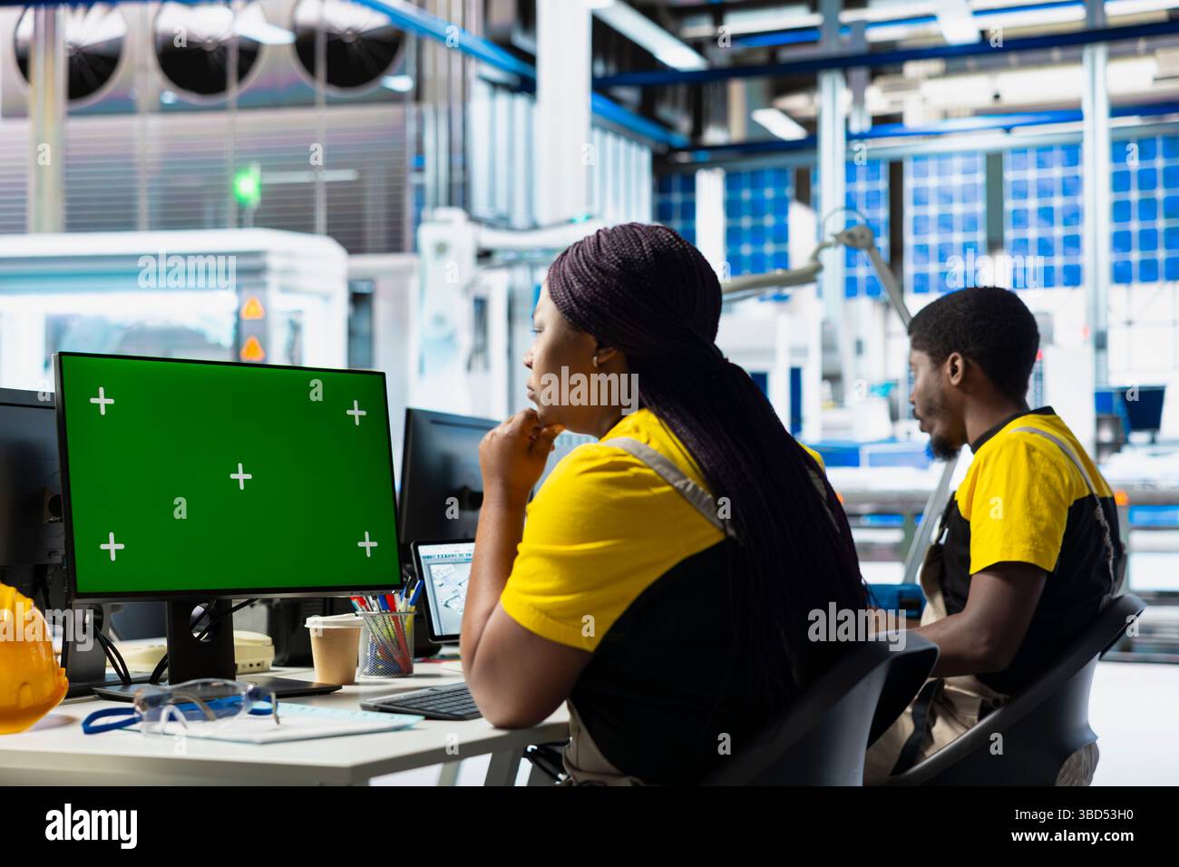 Manufacturing plant employee reviews data on green screen pc to improve ...