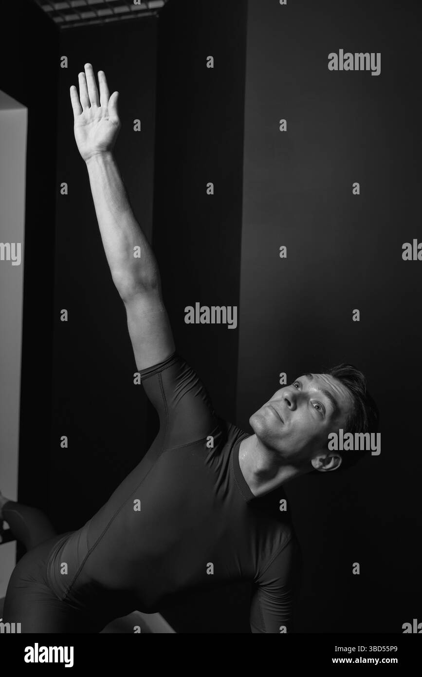 Slim male ballet dancer trains on Pilates equipment. Elegant pose, core ...