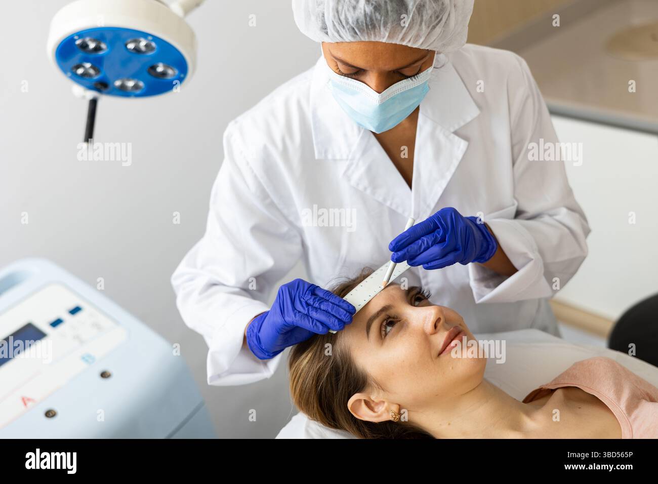 Beautician drawing correction lines on woman face Stock Photo - Alamy