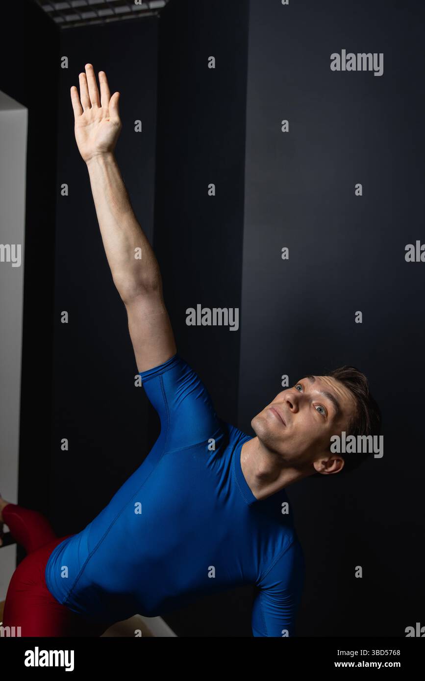 Slim male ballet dancer trains on Pilates equipment. Elegant pose, core ...