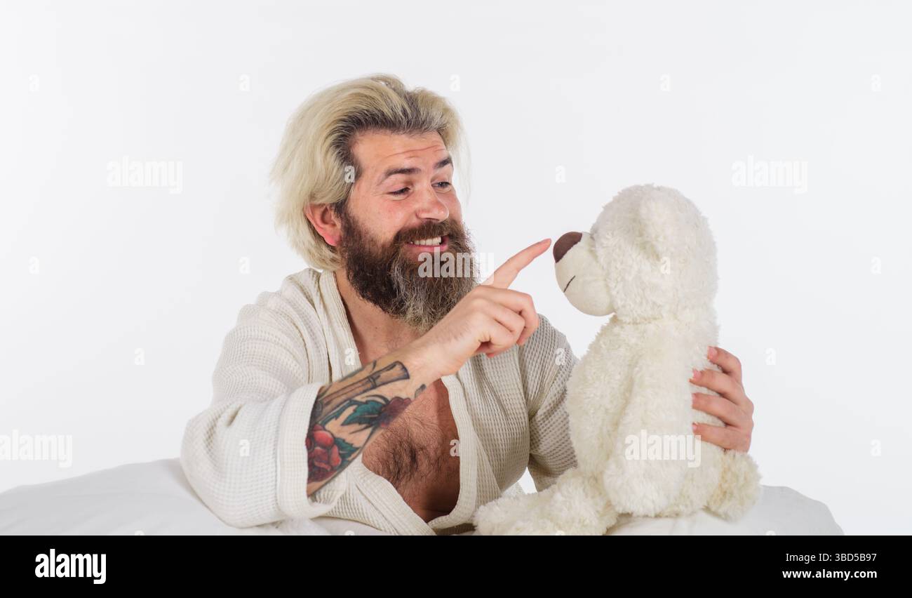 Man with teddy bear. Bearded man resting in bed with teddy bear ...