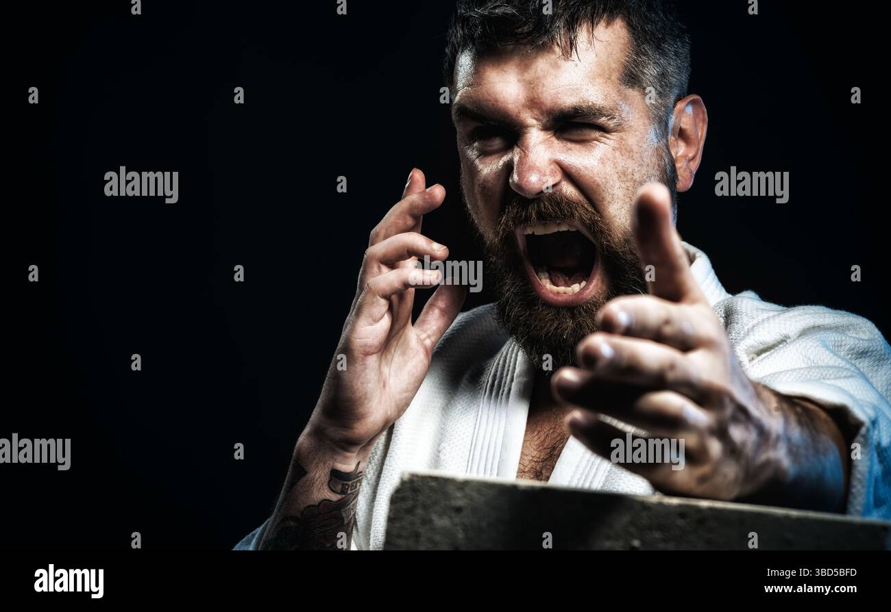 Strong karate man in kimono shows kick by hand. Karate master preparing ...