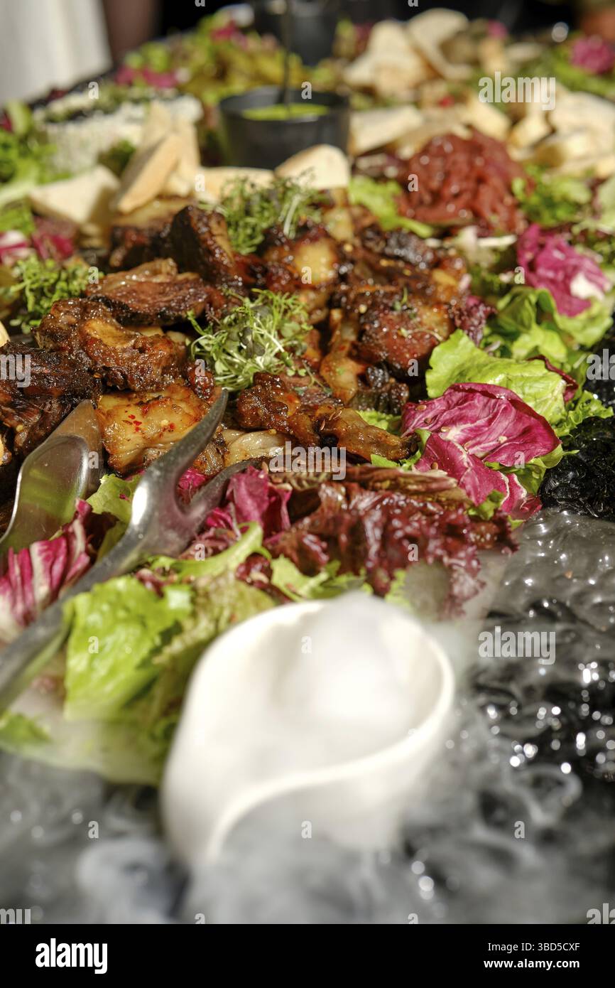 A banquet table is adorned with an extravagant display of grilled meats ...