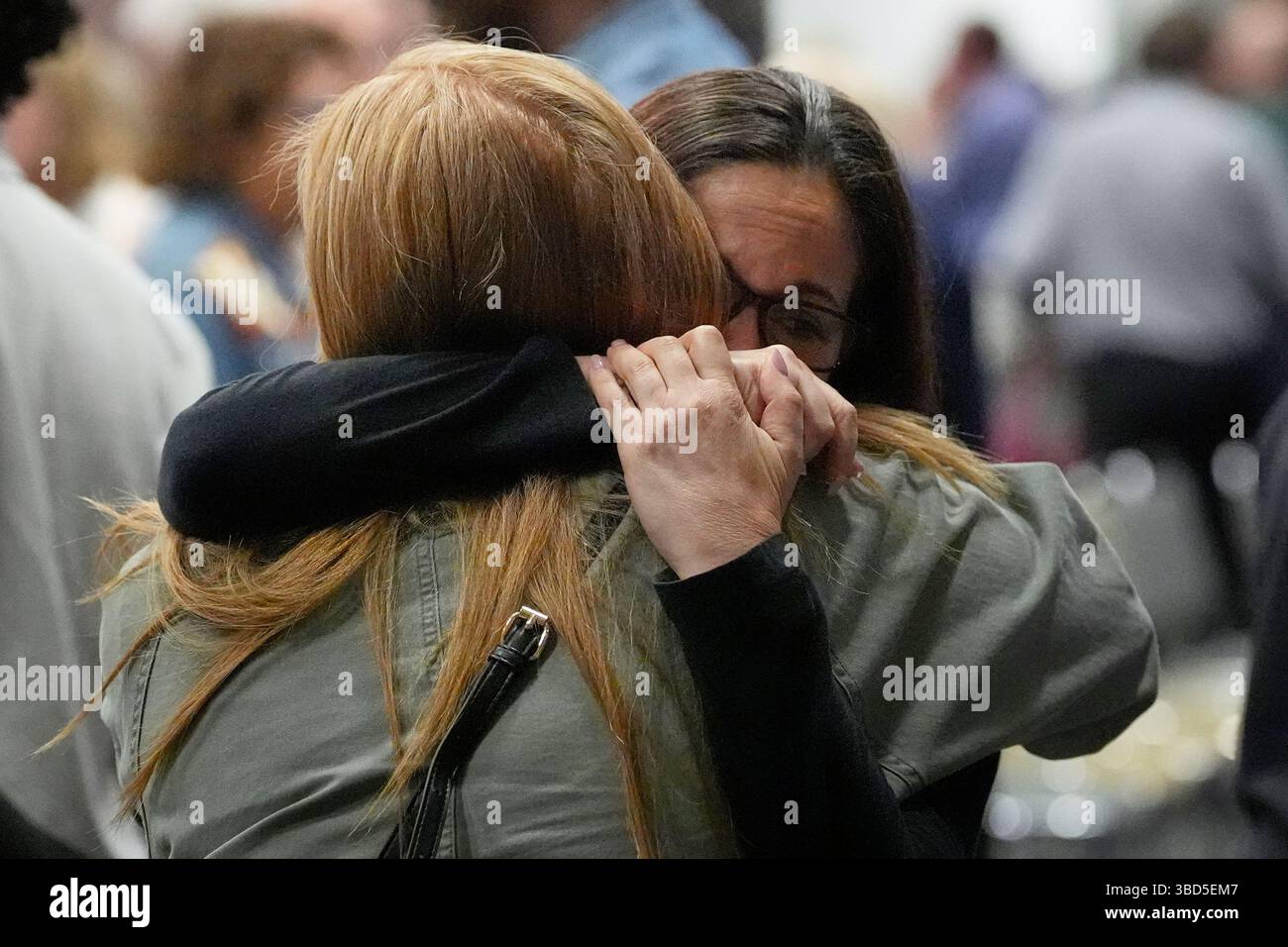 People hug at the Jewish Community Center of Greater Kansas City before ...