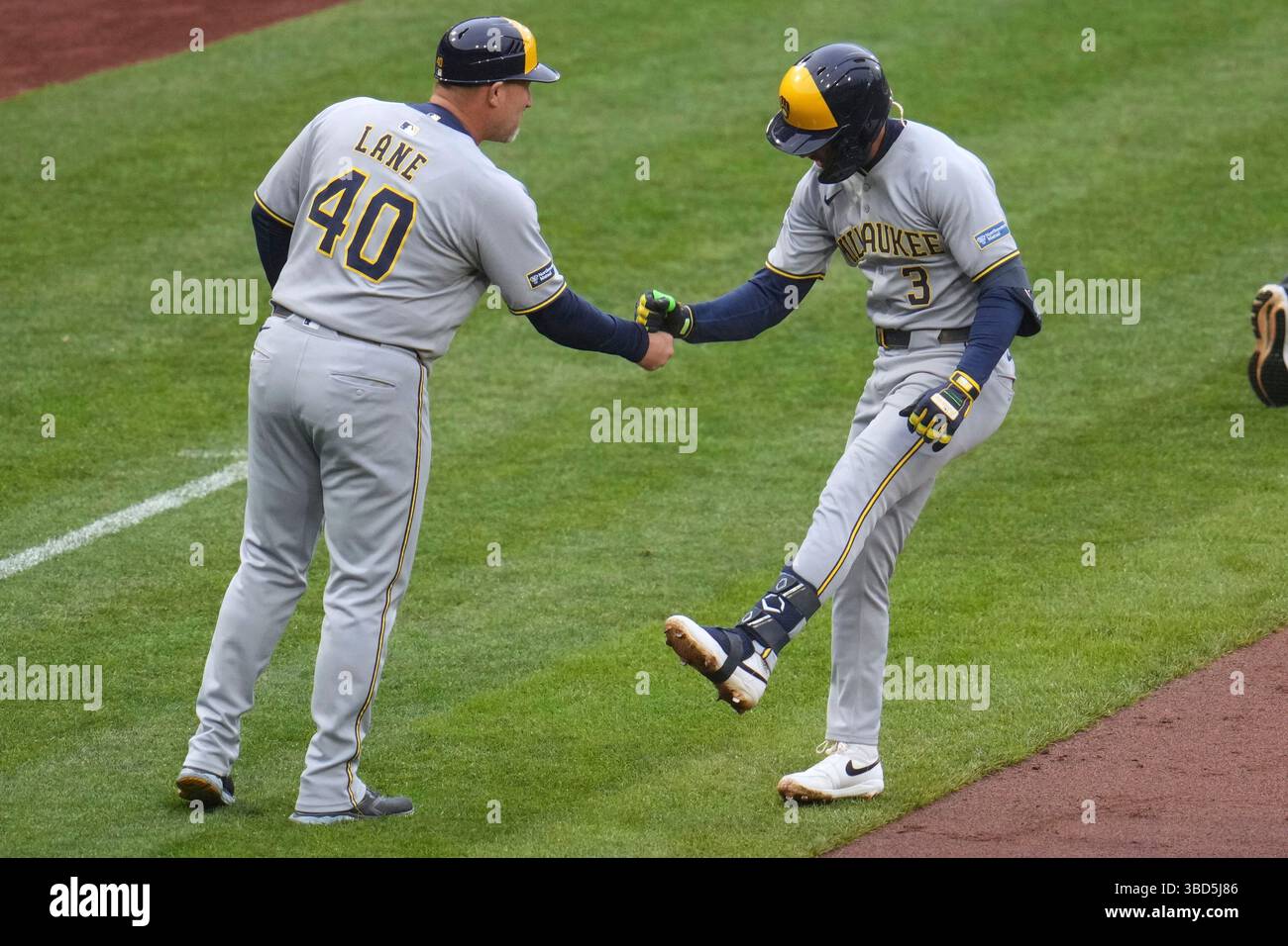 Milwaukee Brewers' Joey Ortiz, right, celebrates with third base coach ...