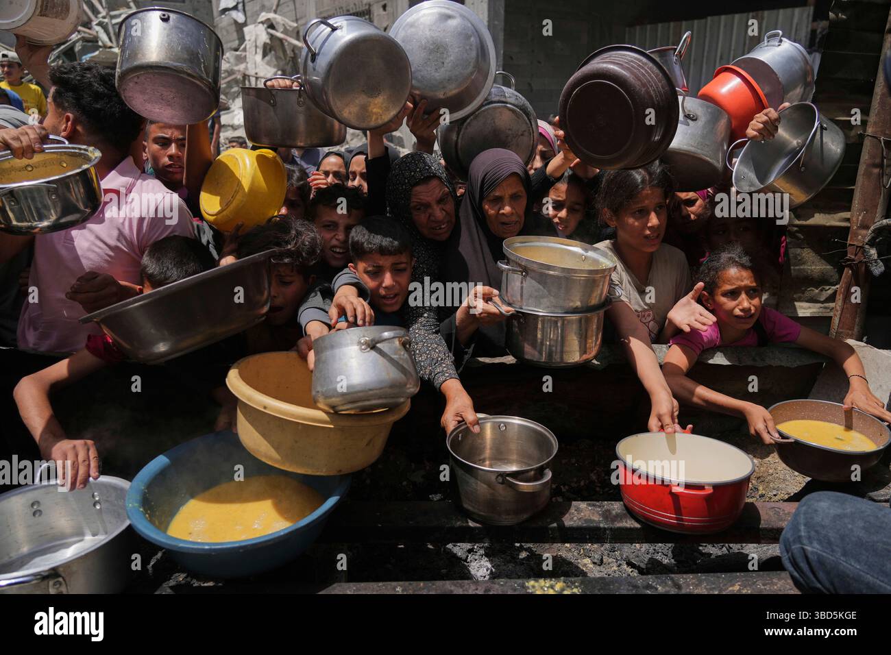 Palestinians struggle to get donated food at a community kitchen in ...