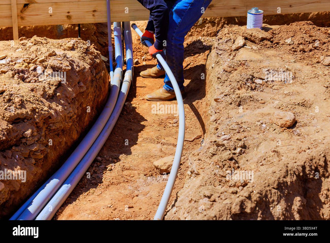 Man works diligently installing electrical pipe multiple conduits at ...