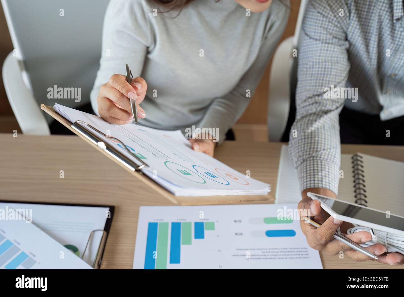 Sustainable data analysis. Professionals reviewing eco-friendly business metrics in modern ...