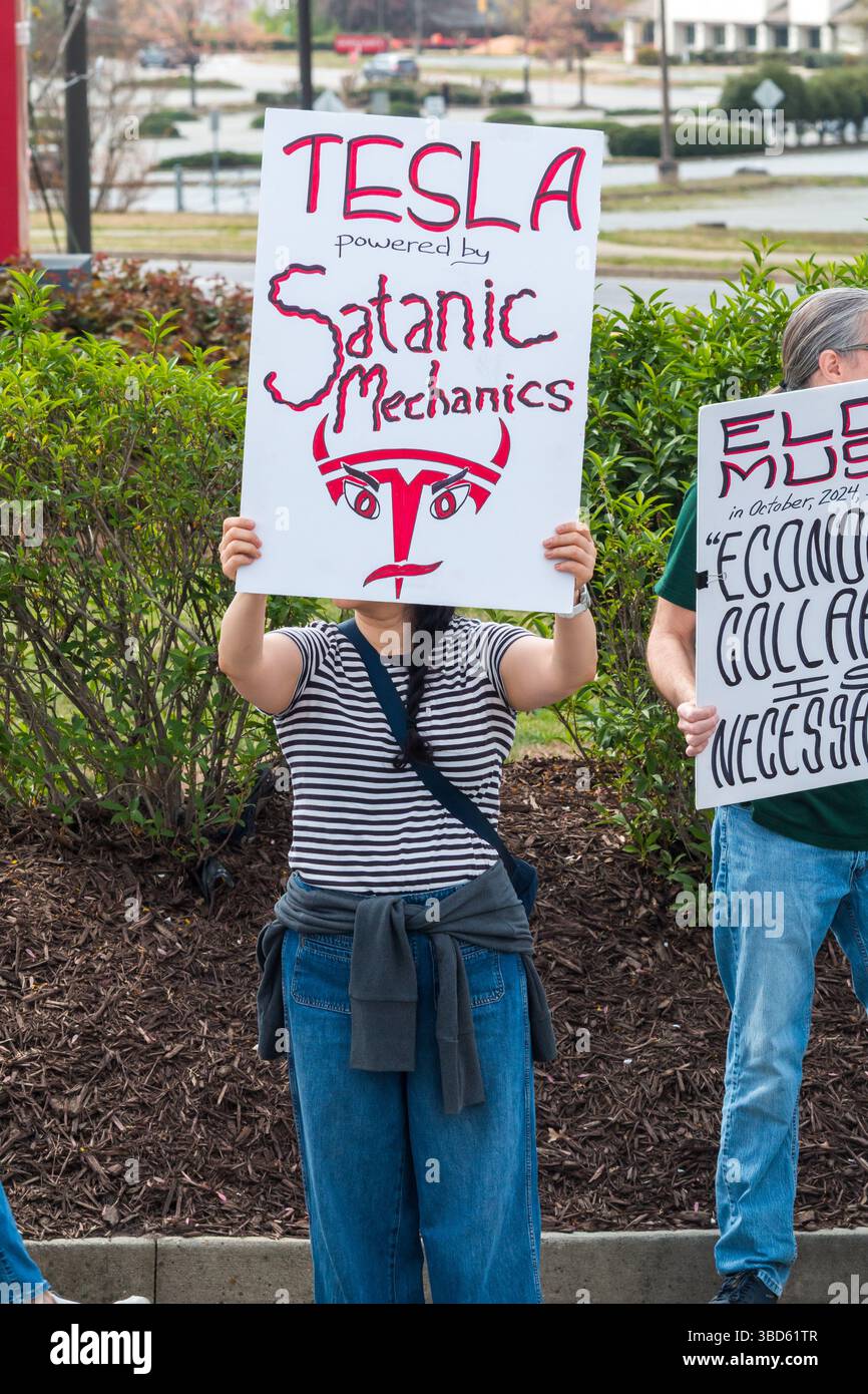 Duluth, GA / USA - March 29, 2025: Woman holds sign reading "Tesla ...