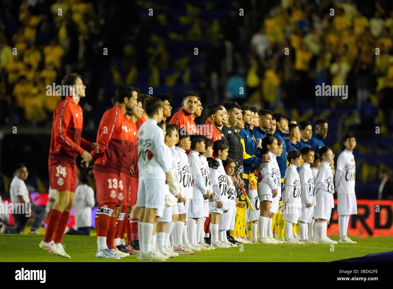 Players of Toluca, left, and America line up for the national anthem ...